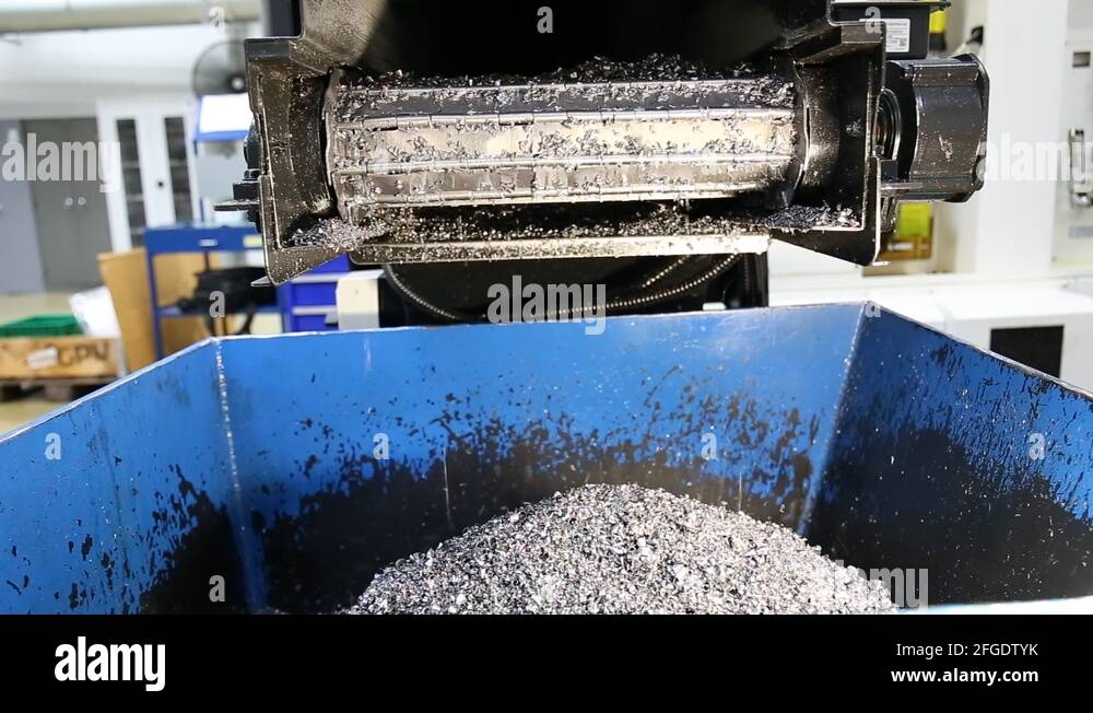 Chip conveyor moving steel chips from coolant tank to the scrap bin ...