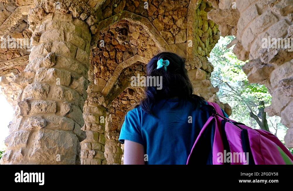 Woman admires arch of colonnaded path in Antoni Gaudi's Park Guell ...