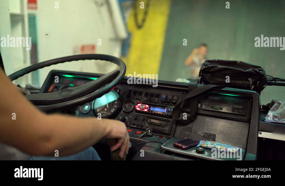 Bus driver driving intercity coach to load on car passenger ferry boat ...