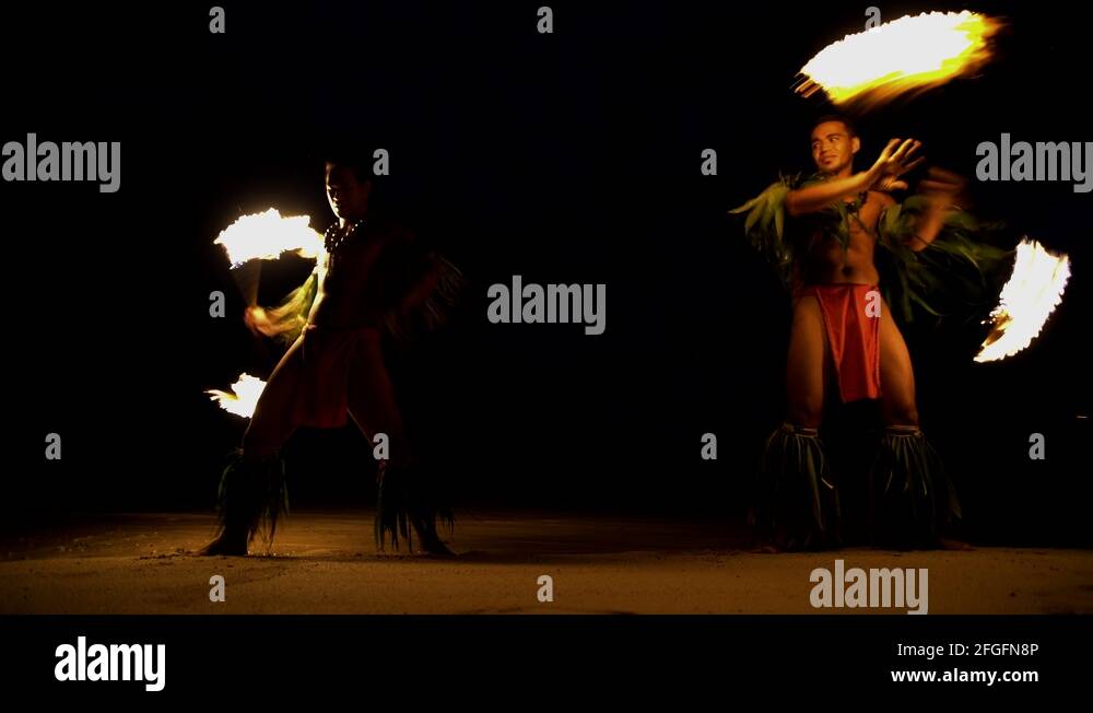 Polynesian male Fire dancers performing with spinning flaming torches ...