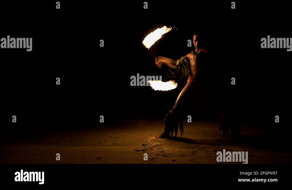 Male Fire dancer with illuminated spinning flaming torch performing the ...