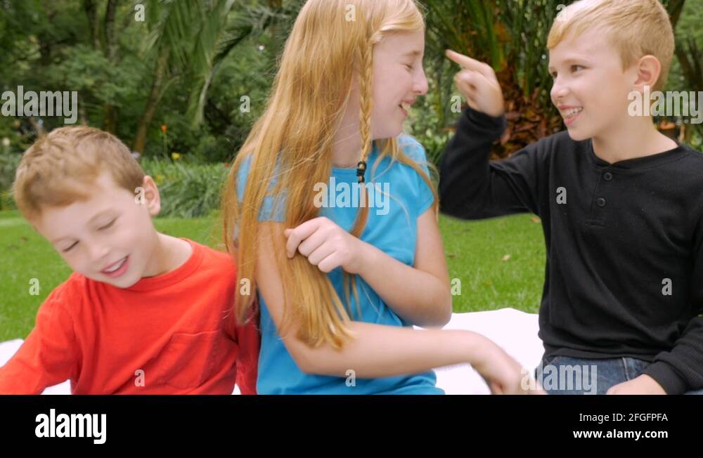 Three siblings poking and tickling each other outside - slowmo handheld ...