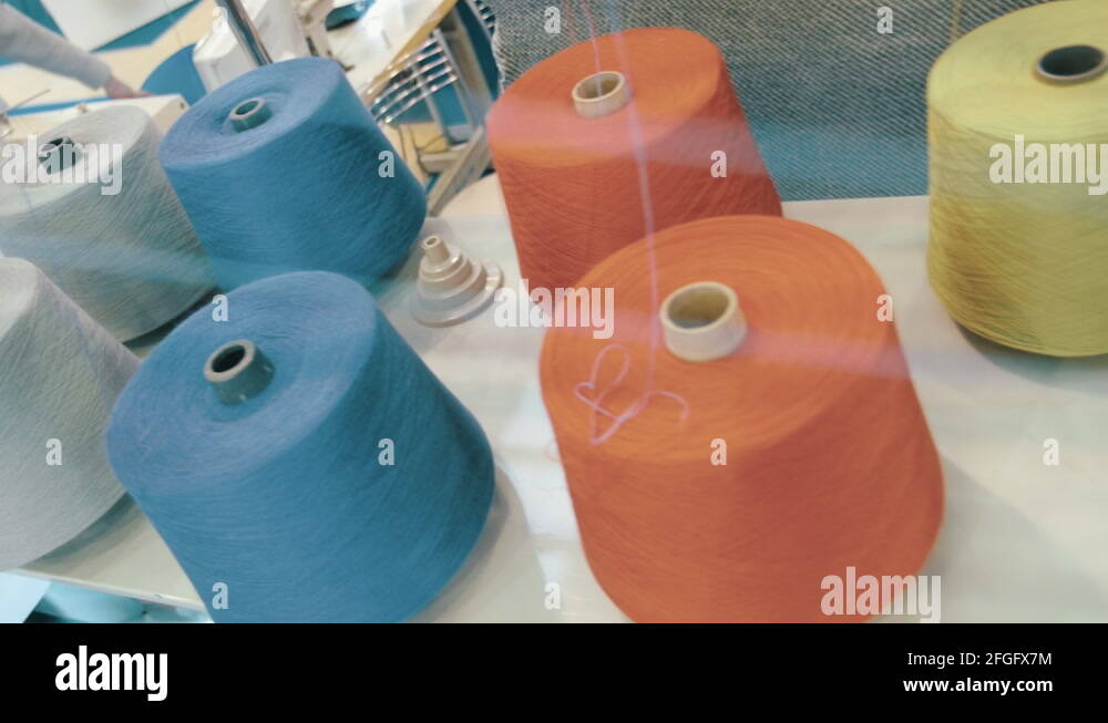Rows spools of thread of different colors in the industrial sewing ...