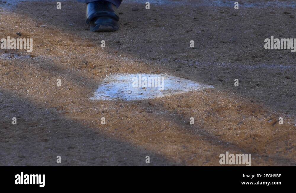 An umpire brushes off home plate at a baseball game, slow motion Stock ...