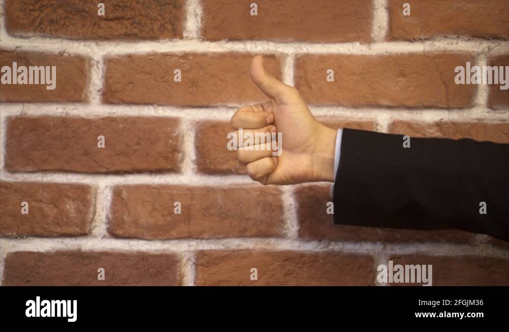Thumbs up - Brick wall background Stock Video Footage - Alamy