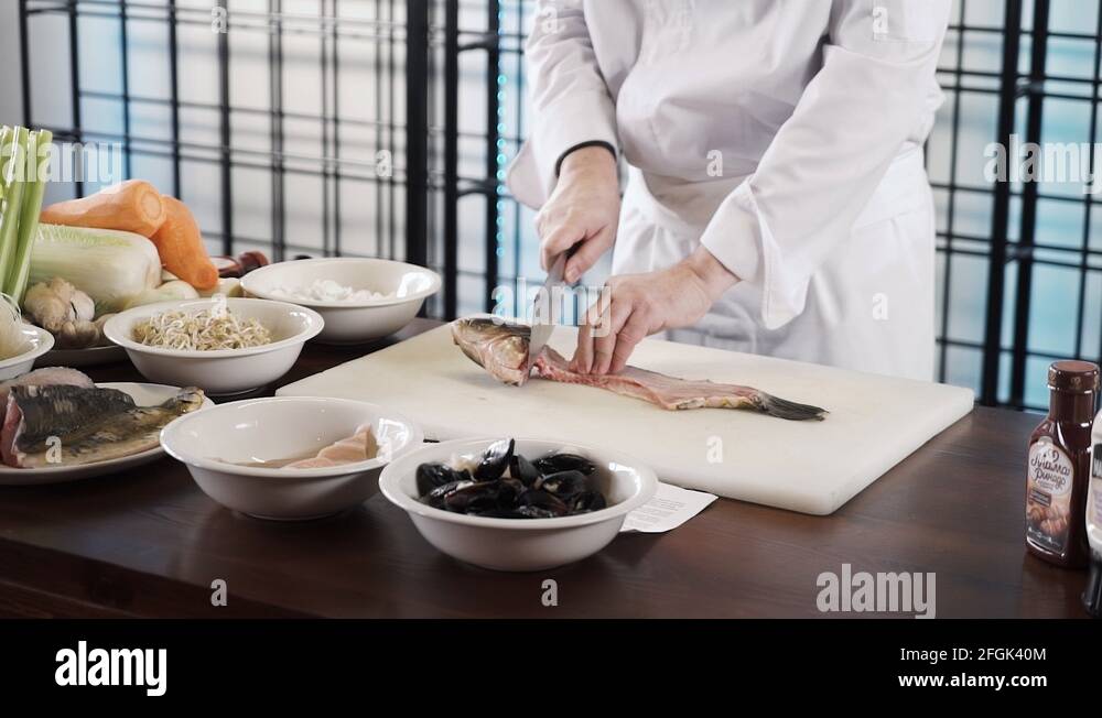 Proseffional chef hands is cutting Fish on his own modern kitchen in ...