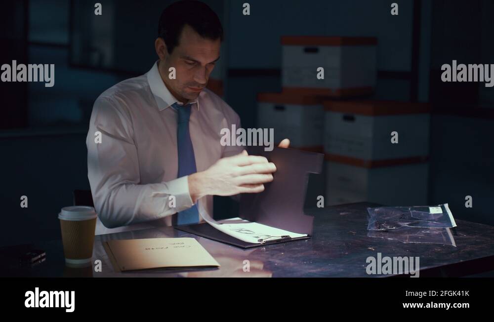 4K Police detective in interview room looking at suspect's file ...