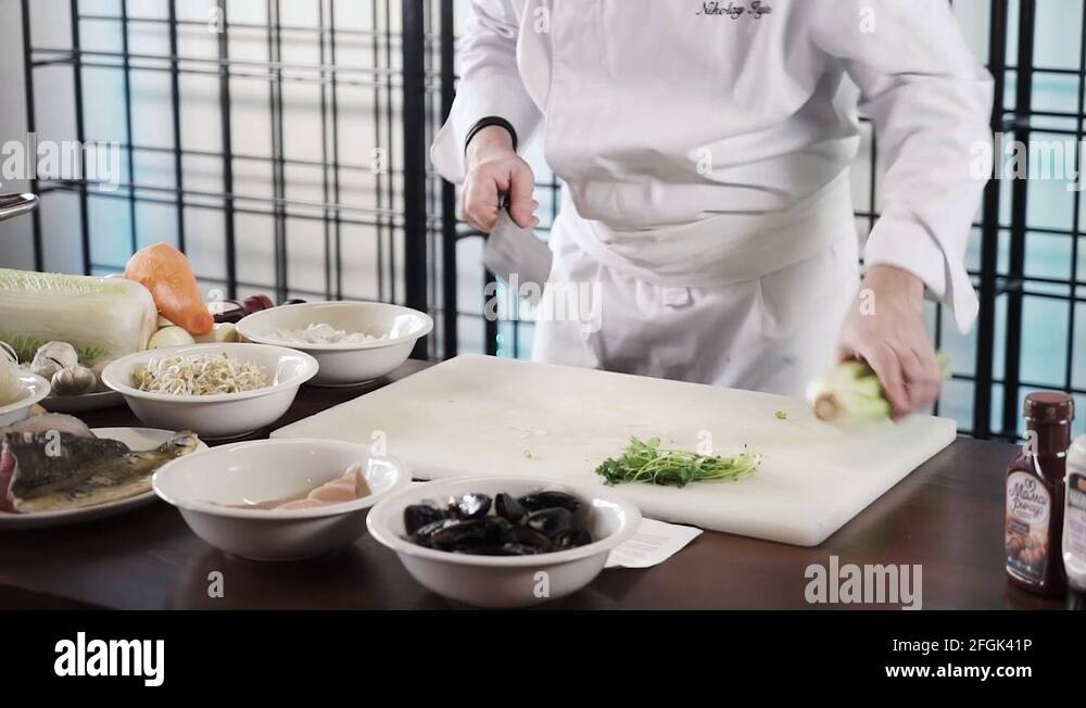 Proseffional chef hands is cutting celery on his own modern kitchen in ...
