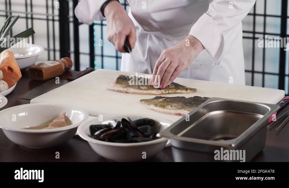 Proseffional chef hands is cutting Fish on his own modern kitchen in ...