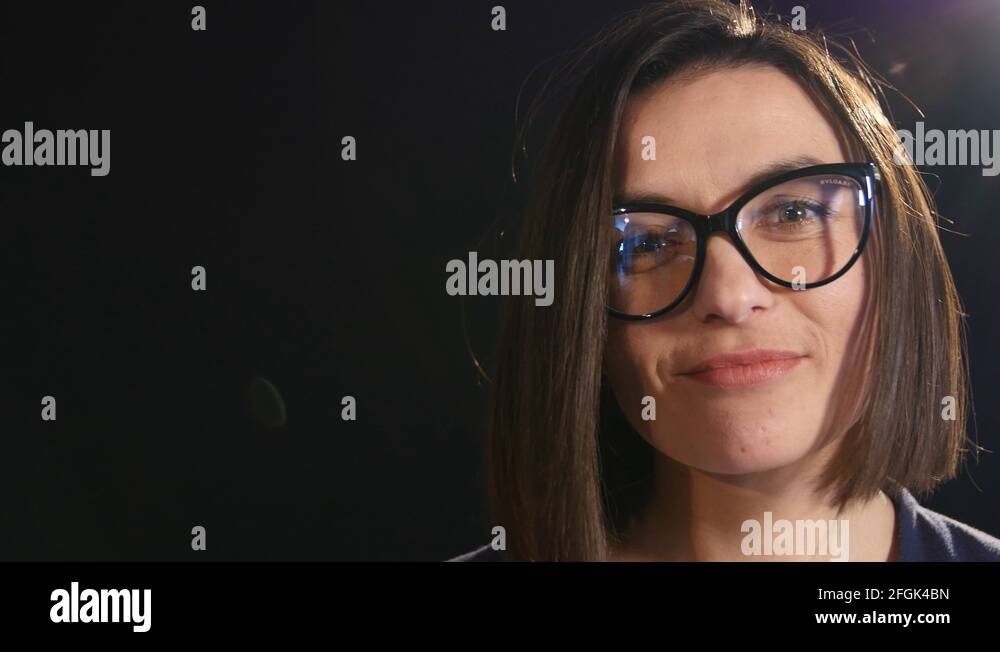 Beautiful young professional woman removing her glasses on black ...