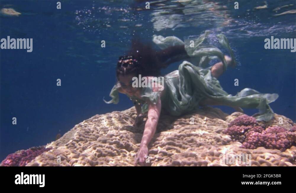 Underwater model free diver swims in clean transparent blue water in ...