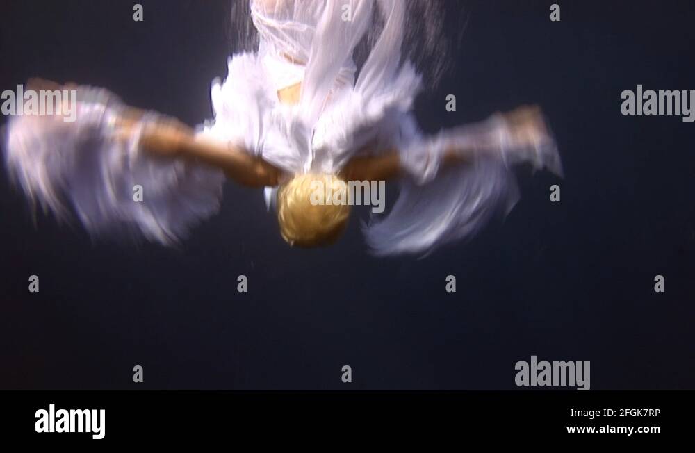 Underwater model free diver in costume angel swims in clean water in ...