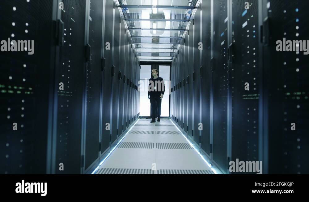 Frontal View Of It Engineer Walking Through Data Center With Working