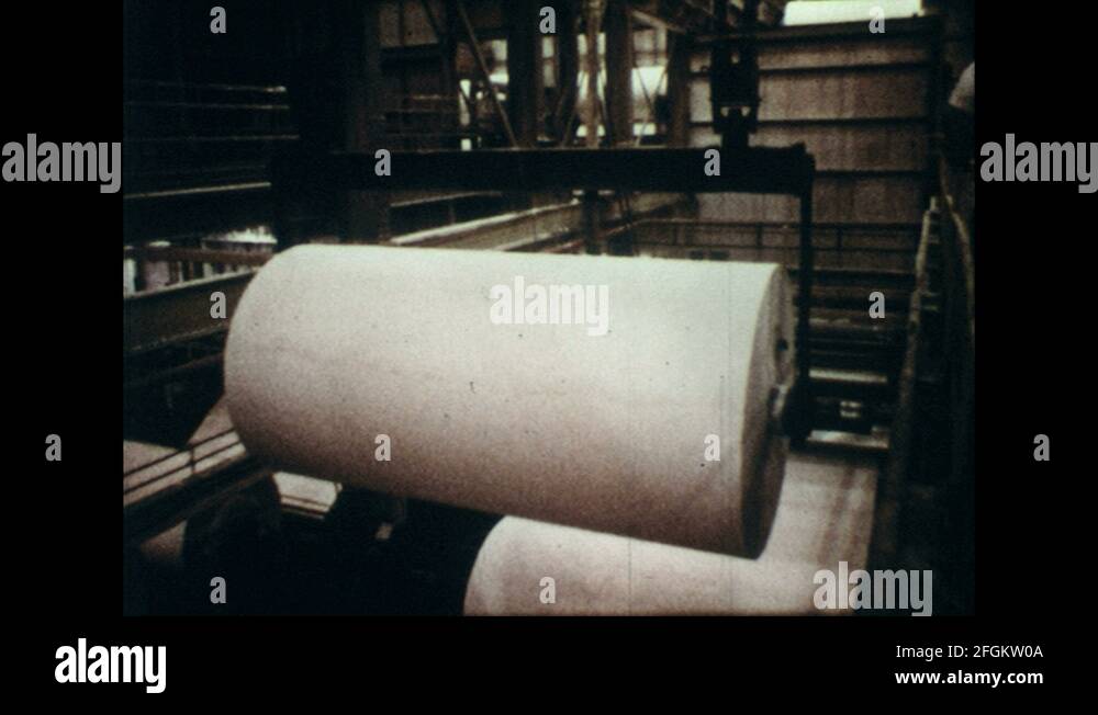 1960s: Roll of paper lowered in factory / Roll of paper lifted by crane ...