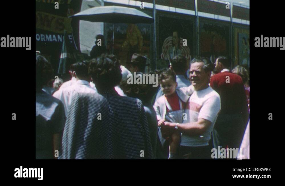 1950s: Crowd walking through circus / Sideshow performers walk onto ...
