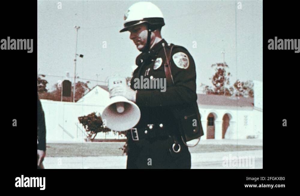1960s: A field commander radios to another police officer as he is ...