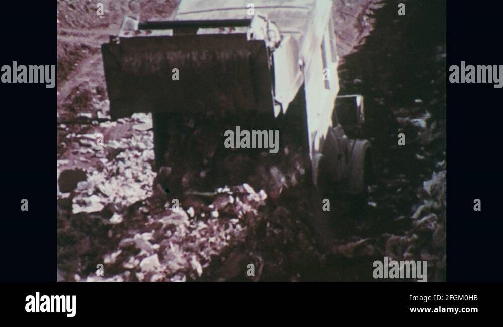 1970s – At a landfill, trash is dropped off by a garbage truck as a ...
