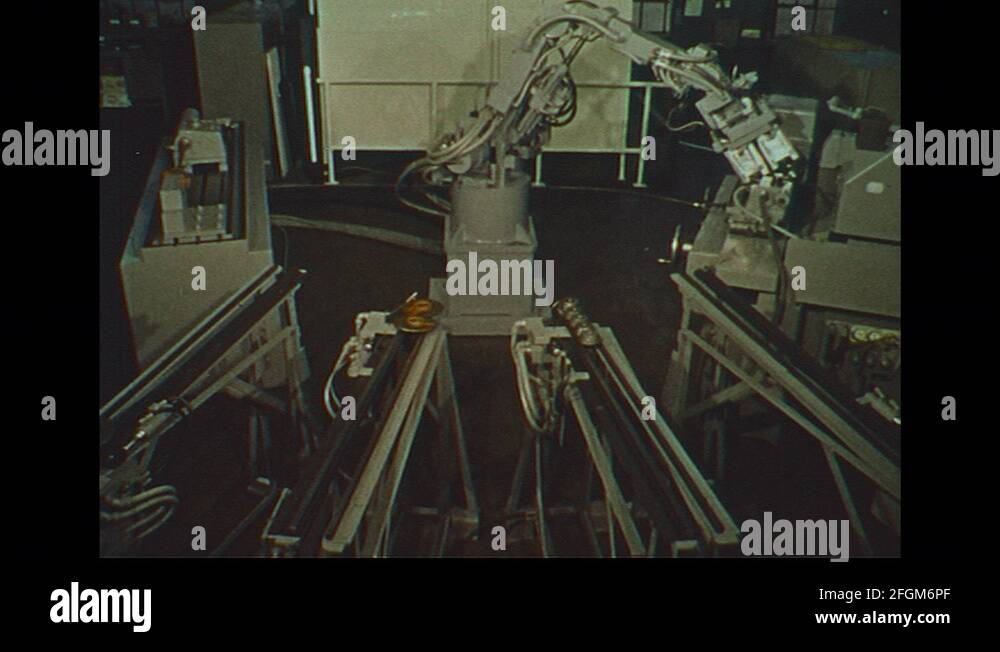 1980s: industrial robotic arm moves pinion from grinding machine to ...