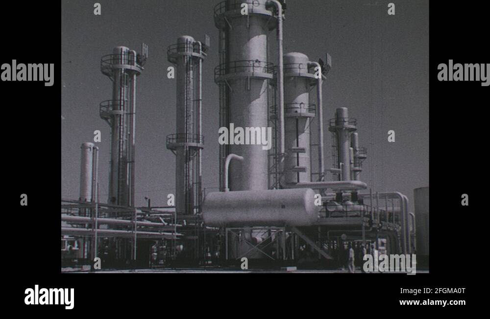 1940s: Exterior of oil refinery / View of compressors in refinery Stock ...