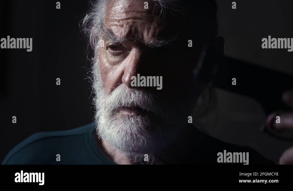 sad depressed old man pointing the gun at the temple, but change his ...