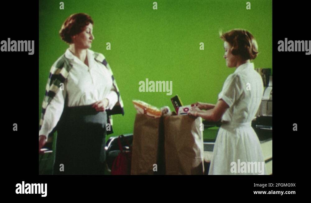 1960s: lady looks at check out girl. Lady unfolds shopping trolley ...