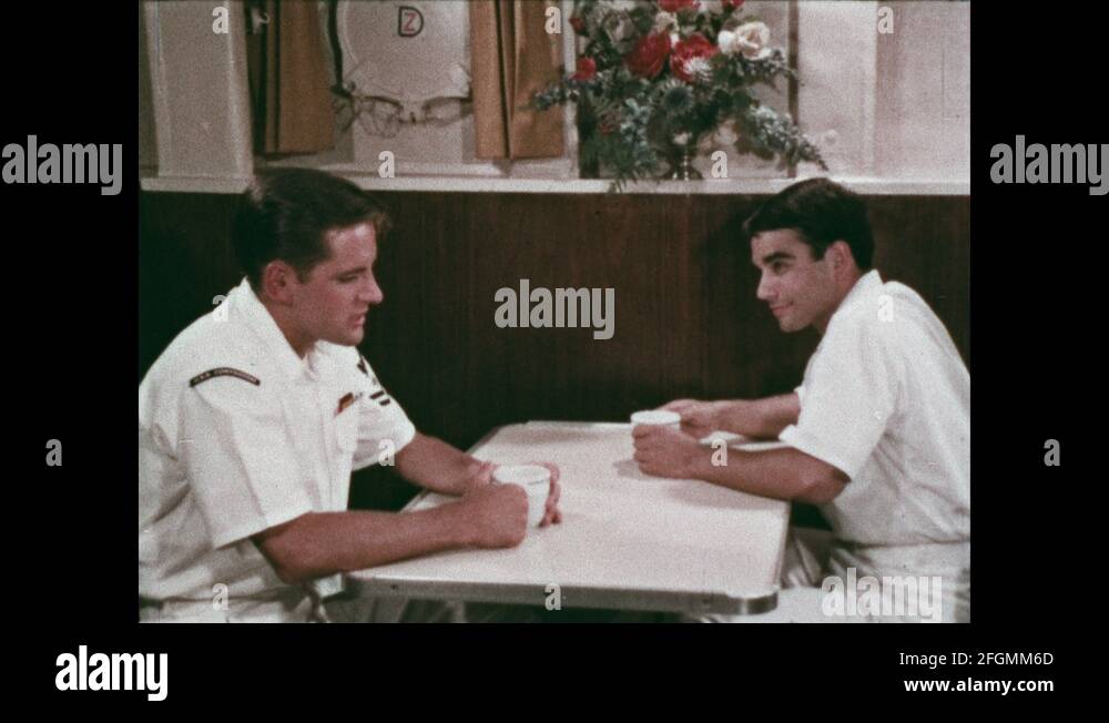 UNITED STATES: 1968: sailors talk at table in canteen. Men smile as ...