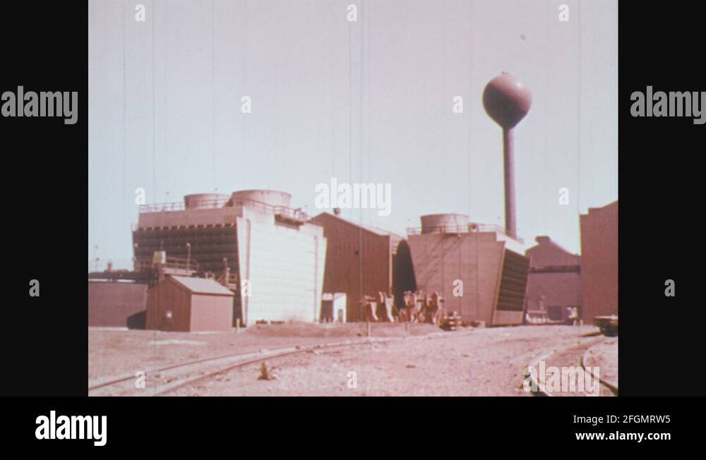UNITED STATES: 1950s: view of external parts of factory. Man inside ...