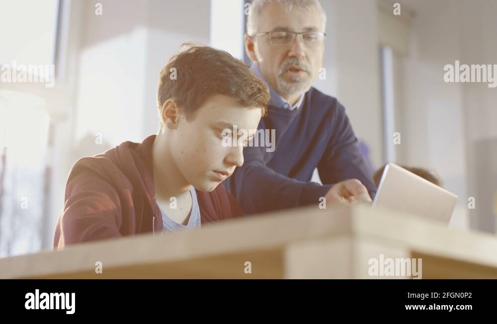 In a Computer Science Class Male Teacher Explains Programming to His ...