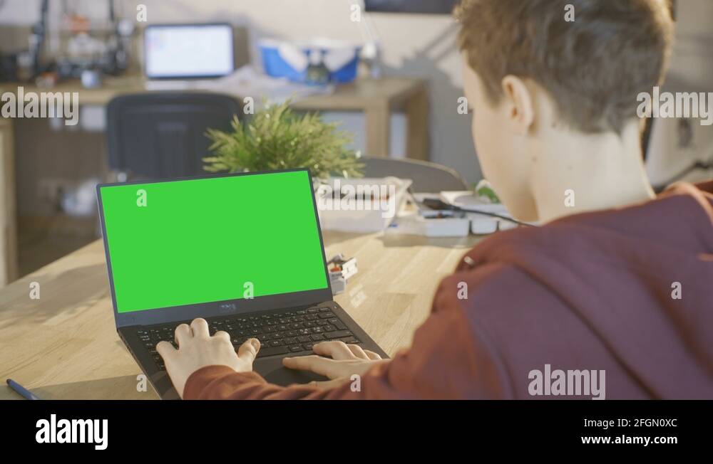 Smart Boy Uses Laptop with Mock-up Green Screen in His Computer Science ...