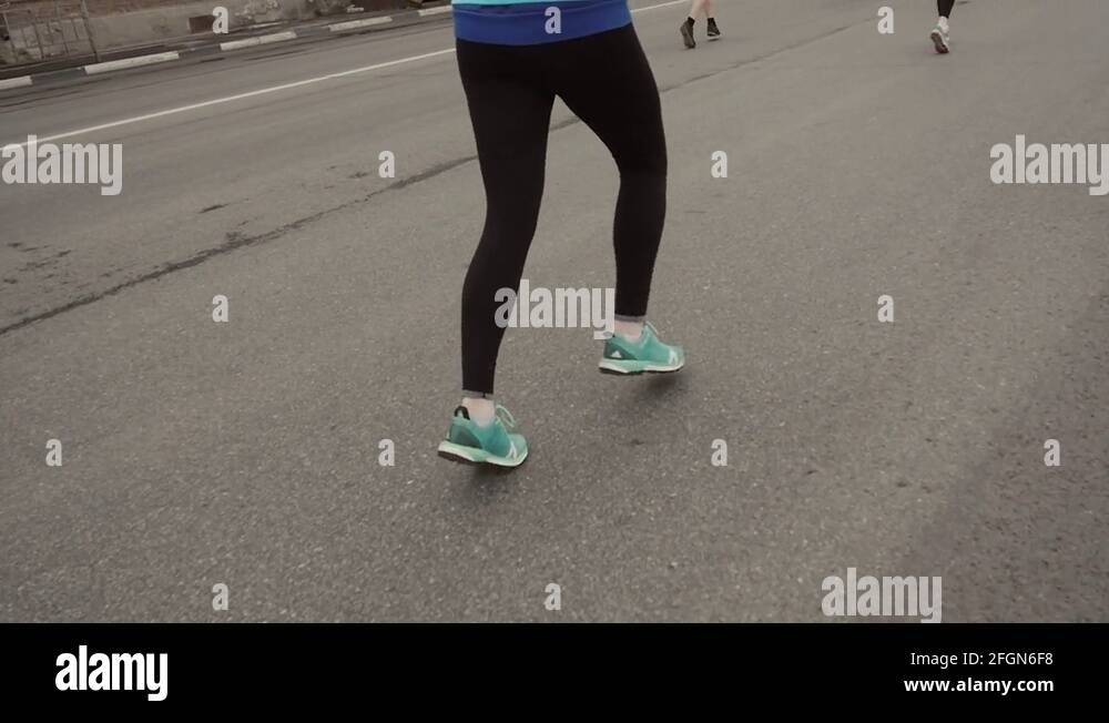 Unidentified marathon athletes legs running on city road, sport legs ...