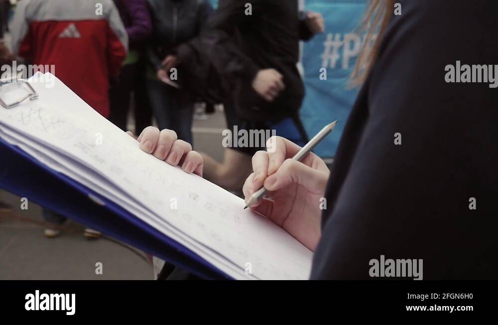 Marathon male athlete crossing the finish line in park, referee judge ...
