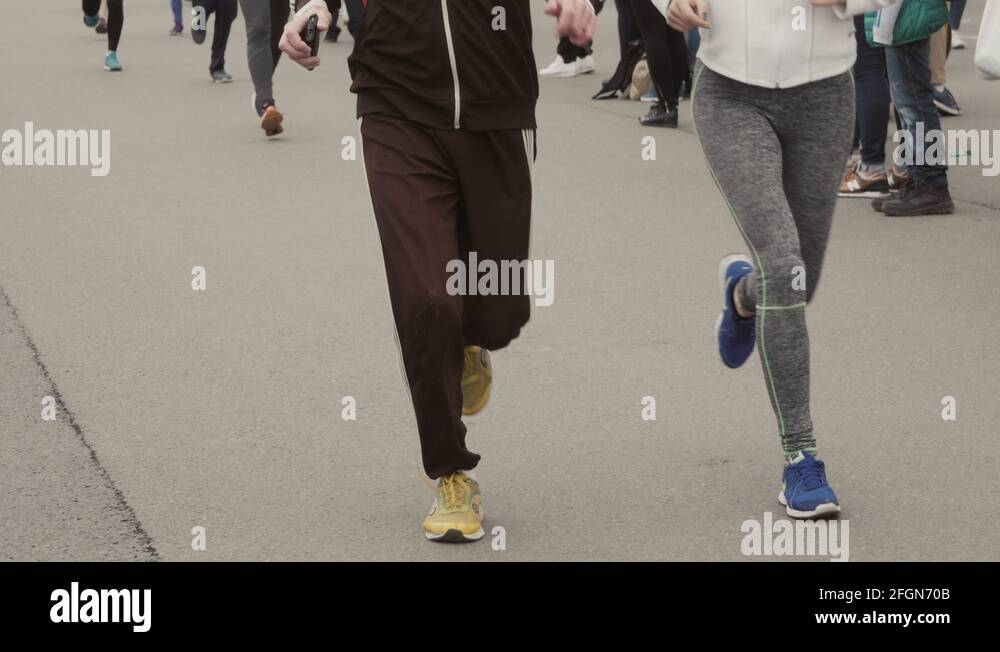 Unidentified marathon athletes legs running on city road, man and woman ...