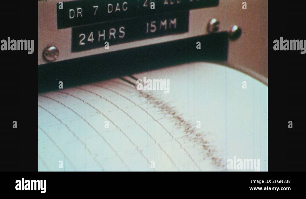 1970s needle records wavelength on drum. man aims camera against window ...