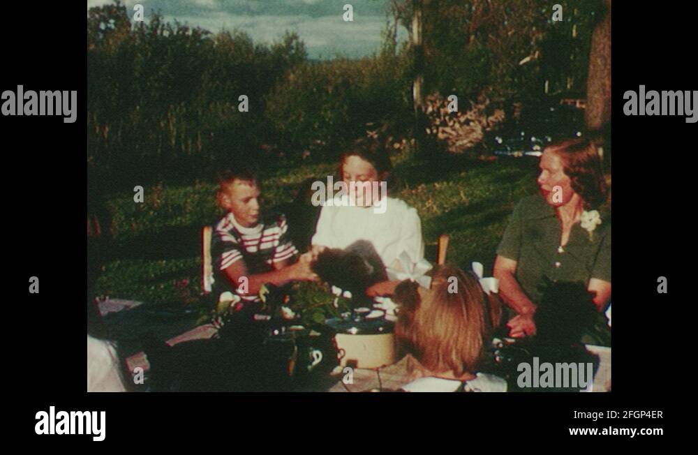 1960s: Family seated at picnic, brother and sister fight over food ...