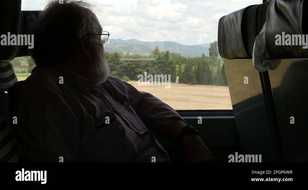 Senior retired man on train looking out window while on vacation Stock ...