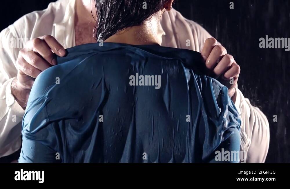 close-up. male hands removed the wet clothes from her shoulder to ...