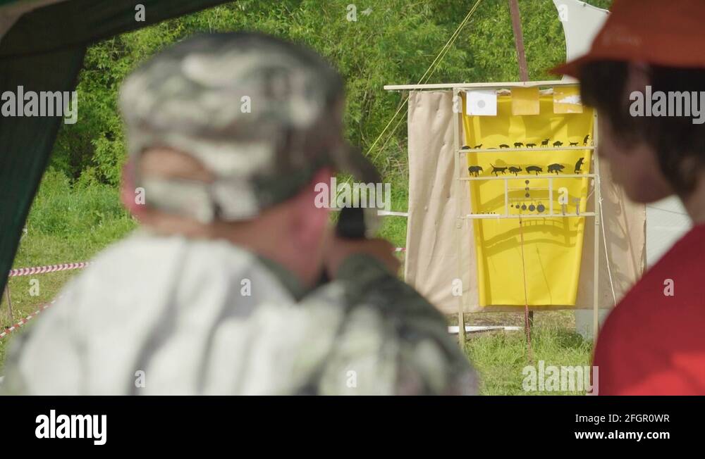 Blur back view of man shooting at yellow aim with animals drawn on it ...