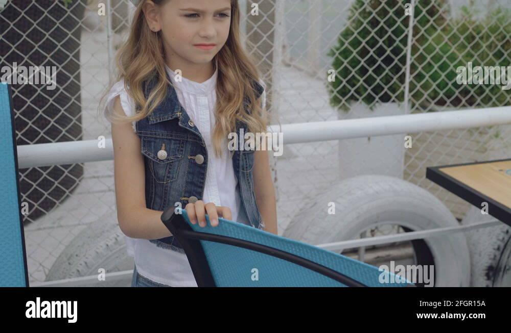 Smart little female model in hat posing, looking and smiling at camera ...