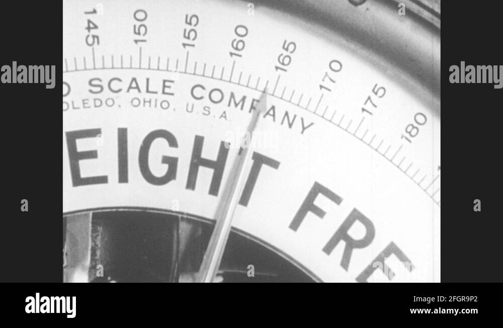1950s: arrow points to 164 pounds on measurement. man steps off scale ...
