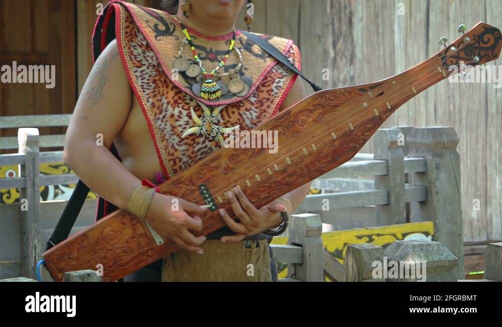 Taman Nusa Indonesian cultural park - man with wooden sapeh Stock Video ...