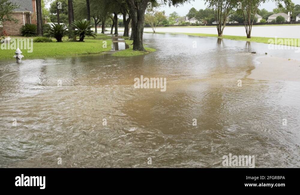 pan of fast moving water on a flooded suburban street 4k Stock Video ...