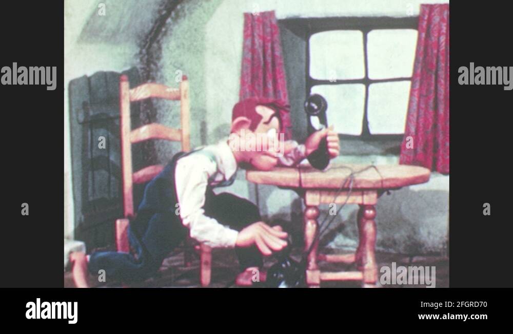1950s: Marionette man puppet sits at table, looks grumpily at telephone ...