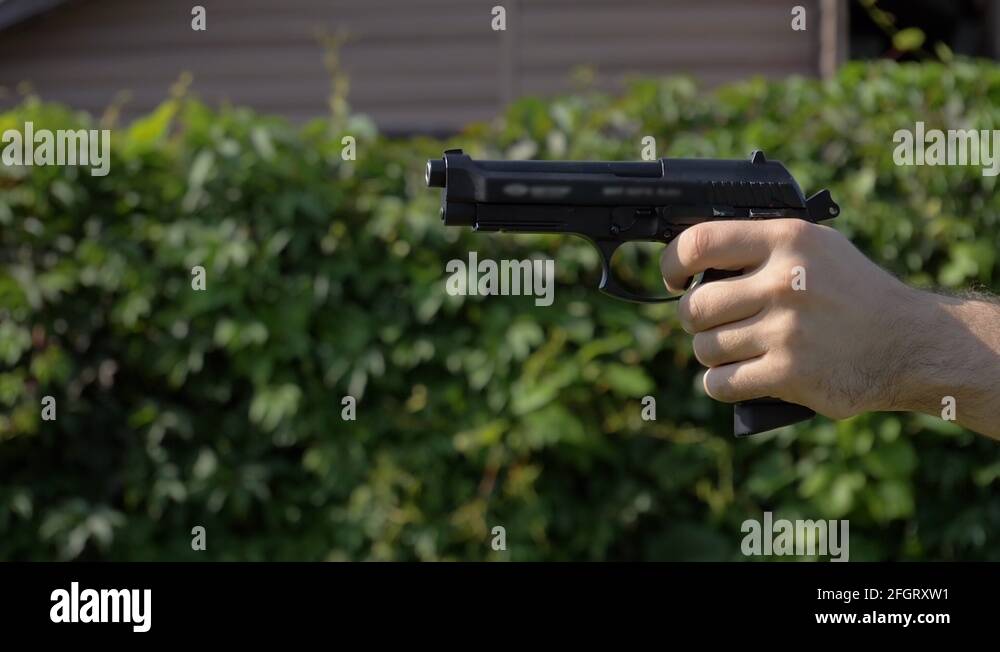 Man hands is shooting a burst from black pistol. Close-up shot. Slow ...