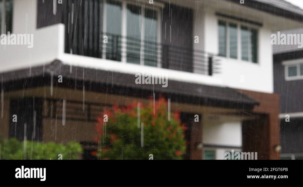 rainy day scene, focus rain falling in sky with blur house background ...