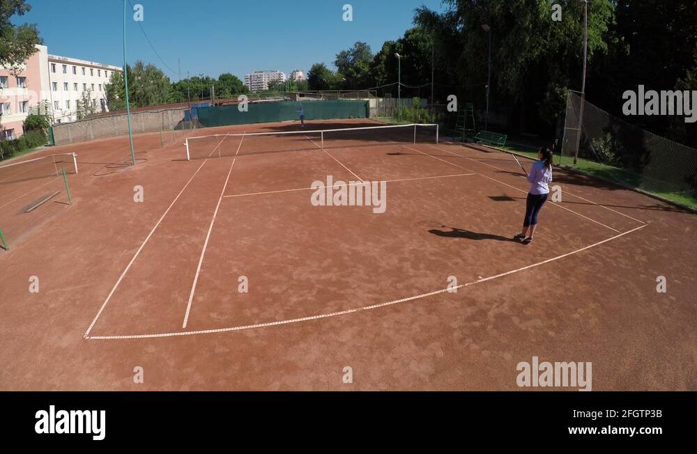Two women play tennis outdoors at tennis arena Stock Video Footage - Alamy