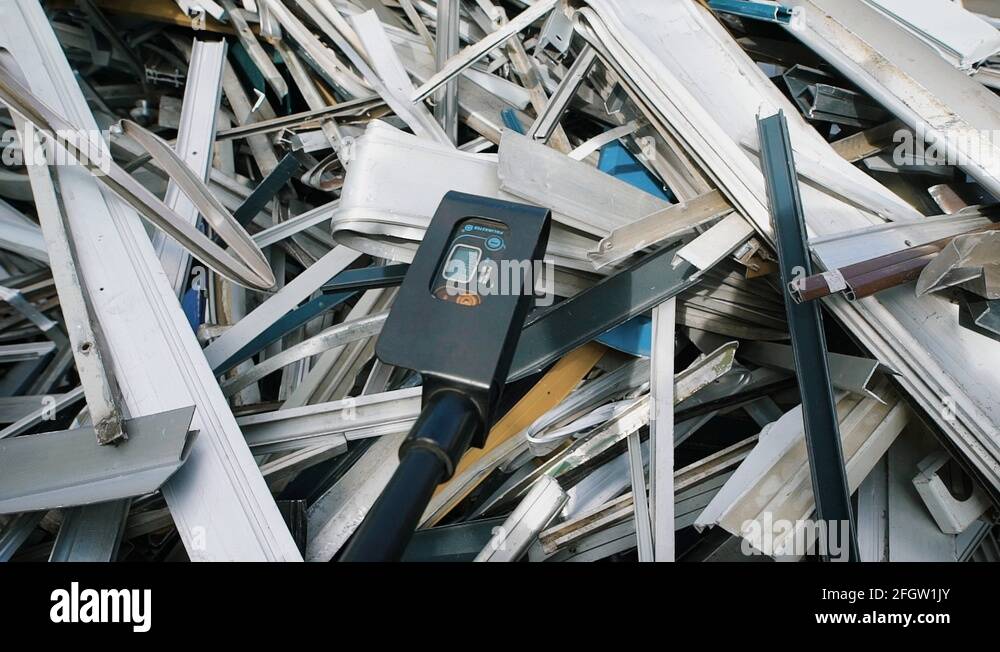 worker is measuring ionizing radiation of heap of scrap metal by modern ...