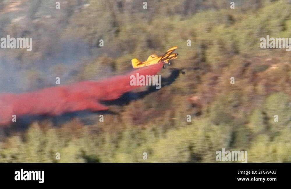 Fire fighting plane fly low and spray fire extinguisher on forest Stock ...