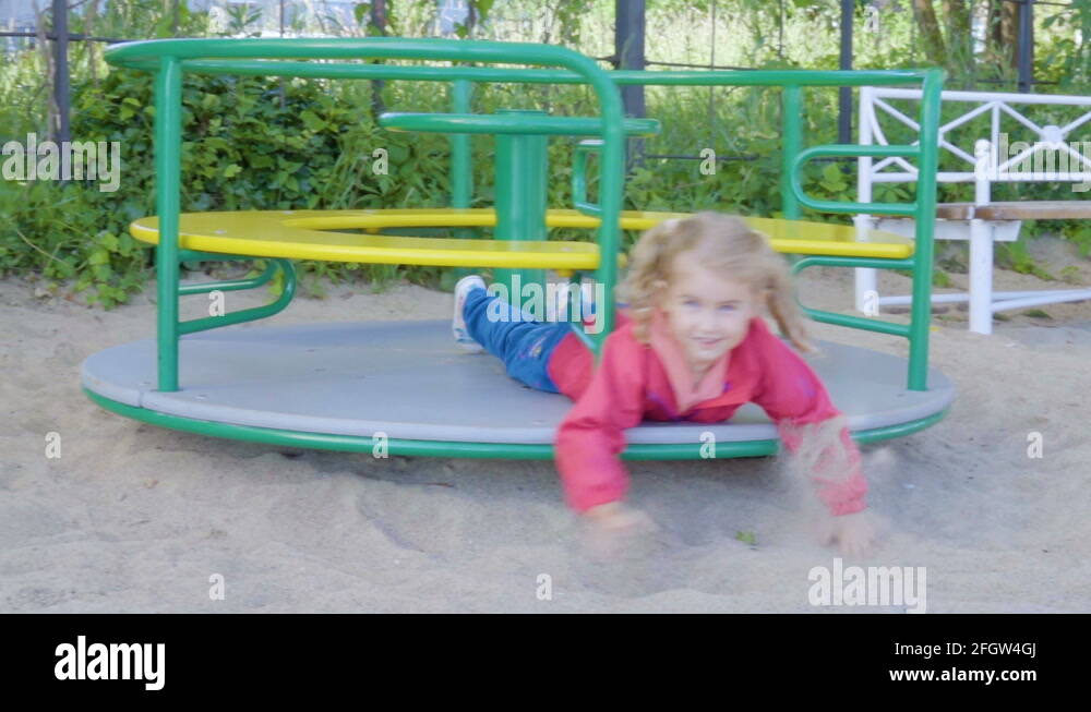 Little Girl Spinning, Rotating on a Merry-Go-Round in Park, View ...