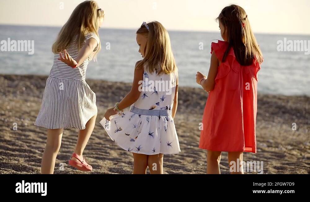 three little girl is wearing different color summer dress are running ...