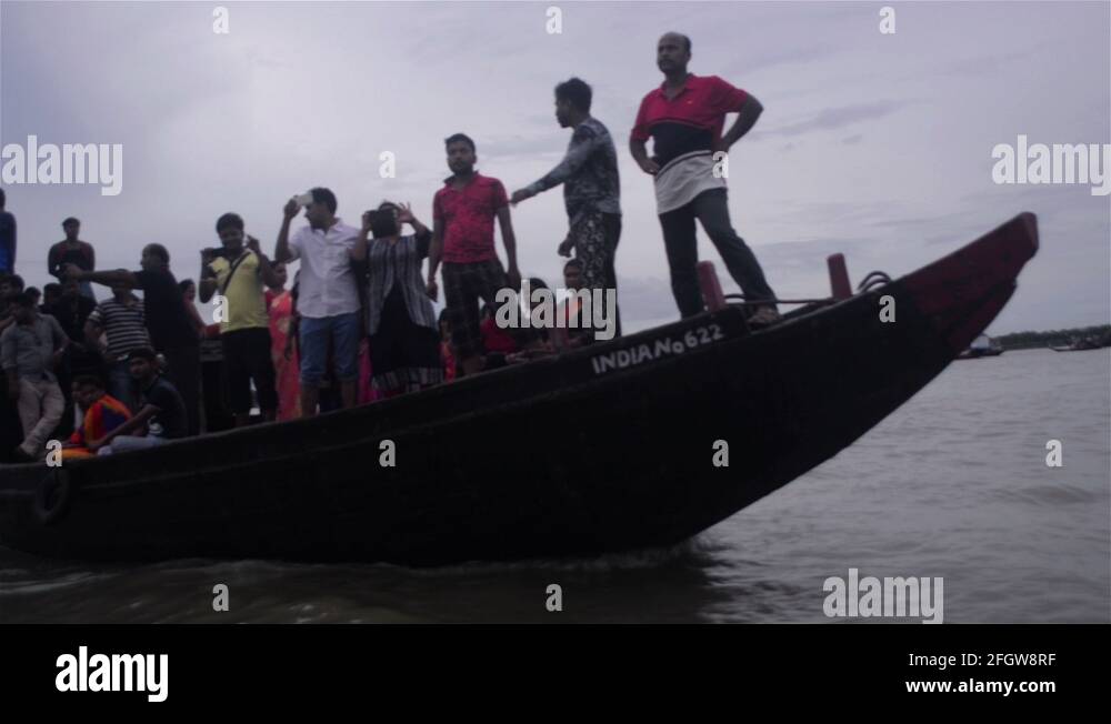 Wide shot of crossing of a crowded wooden boat from a moving boat Stock ...